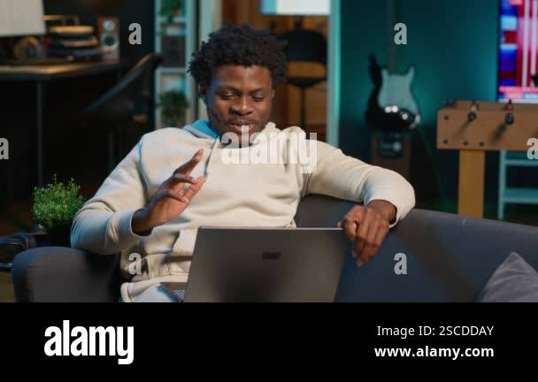 Male remote worker smiling during a virtual meeting with his trainer ...