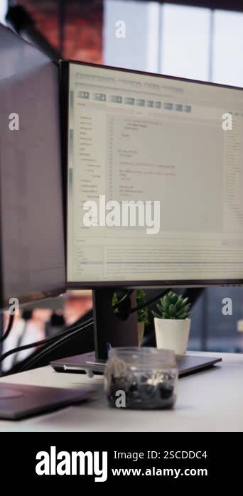 Vertical video Advanced AI algorithms running on computer monitors in empty startup workspace ...