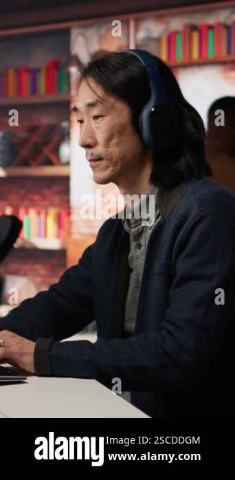 Vertical video AI startup office chief technology officer listening music while coding ...