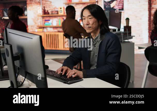 Portrait of smiling senior engineer coding advanced AI algorithm in startup office, refining ...