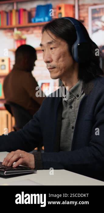 Vertical video Senior admin coding advanced AI algorithm in startup office, refining machine ...