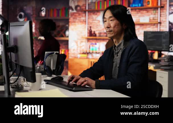 Portrait of smiling senior engineer coding advanced AI algorithm in startup office, refining ...