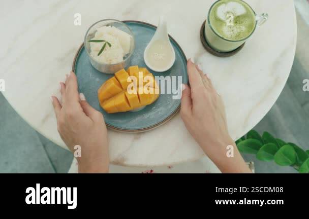 Woman Enjoying Mango Sticky Rice With Coconut Cream and a Matcha Latte ...