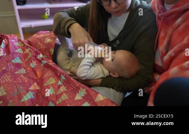 In a comforting and soothing scene, a caregiver gently feeds a little ...