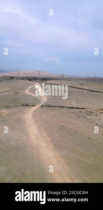 half-finished road in the middle of a desert full of high voltage ...