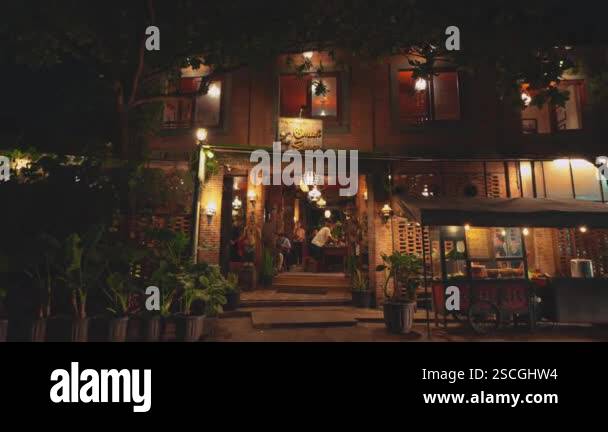 A charming restaurant exterior at night, featuring warm lighting, brick ...
