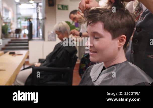 Hairdresser carefully styling client s hair in a salon environment ...