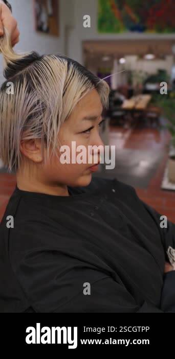 Professional hairdresser lifting wet hair of client in slow motion ...