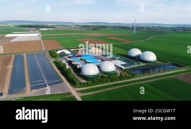 Biogas plant and farm in green fields. Renewable energy from biomass ...