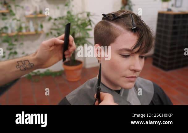 Professional hairdresser skillfully cutting clients hair using scissors and comb, capturing ...