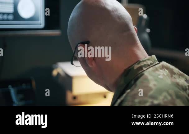 Back handheld shot of adult male commander writing strategy plan while ...