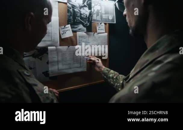 Back view of two military officers in uniform standing by bulletin ...