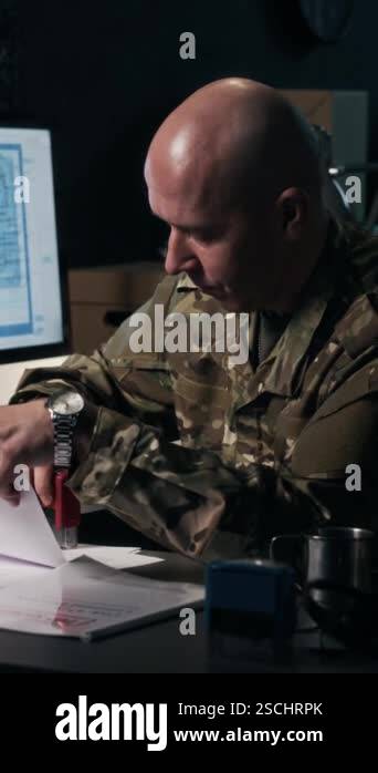 Vertical shot of Caucasian commander in military uniform reviewing ...