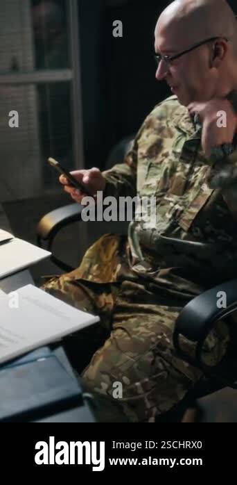 Vertical low key shot of adult tired male officer in military uniform ...
