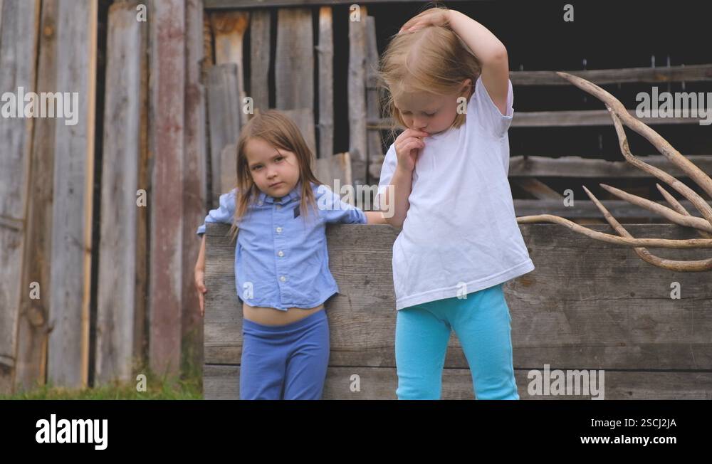 Two little cute sad girls are posing in a rustic setting Stock Video ...
