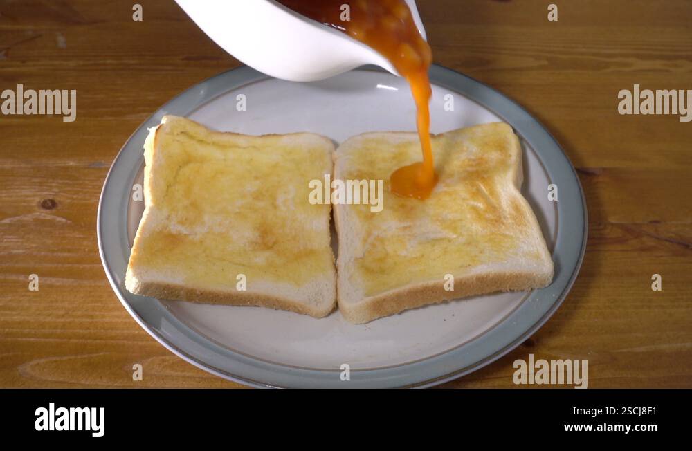 Slow motion – Man’s hands pouring traditional hot baked beans on ...