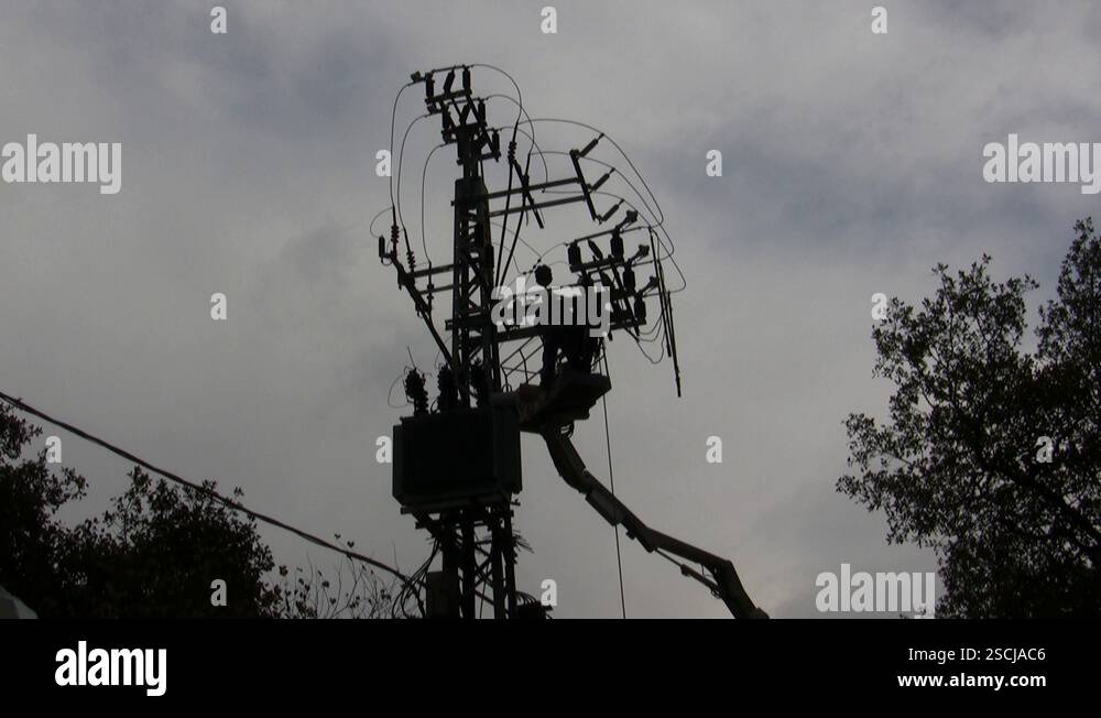 Electricians in a bucket fixing high voltage electrical lines Stock ...
