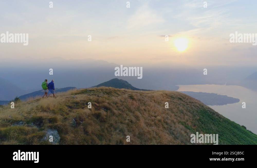 Drone shot aerial view of Father and daughter hiking on mountain top in ...