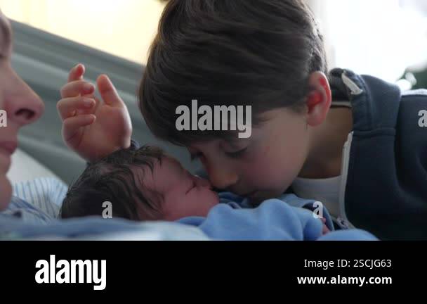 Young boy meeting his newborn baby brother for the first time at ...