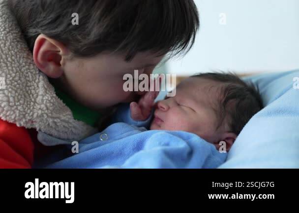 Tender interaction between big brother and newborn baby, highlighting ...