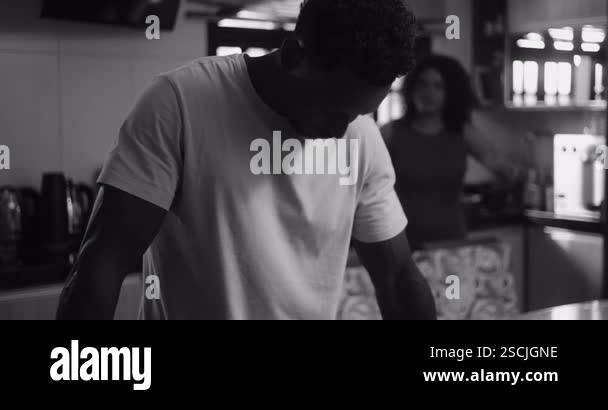 Husband leaning on kitchen counter, head down, emotional distress, wife ...