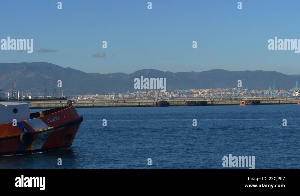 A tugboat, the 'Eliott' in Gibraltar harbour. Passing left to right ...
