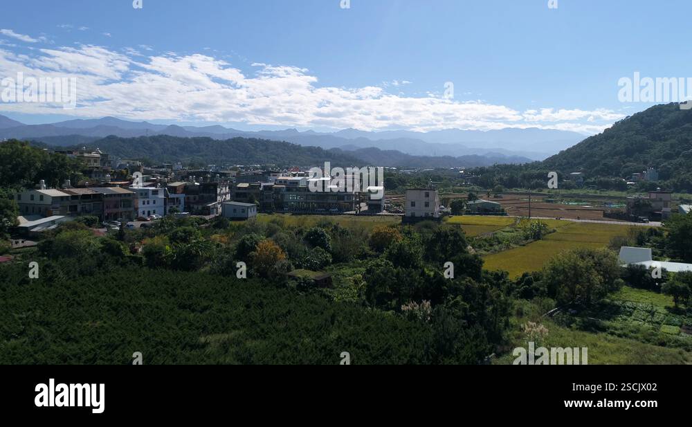 Aerial shot of a village beside a river and farms Stock Video Footage ...