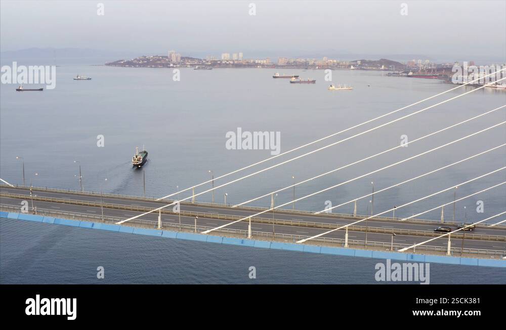 Flying sideways, aerial view of Russian bridge road, ship floating ...