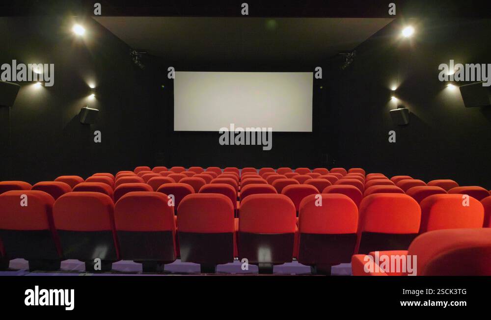 Traveling over red cinema seat row with screen in background. Movie ...