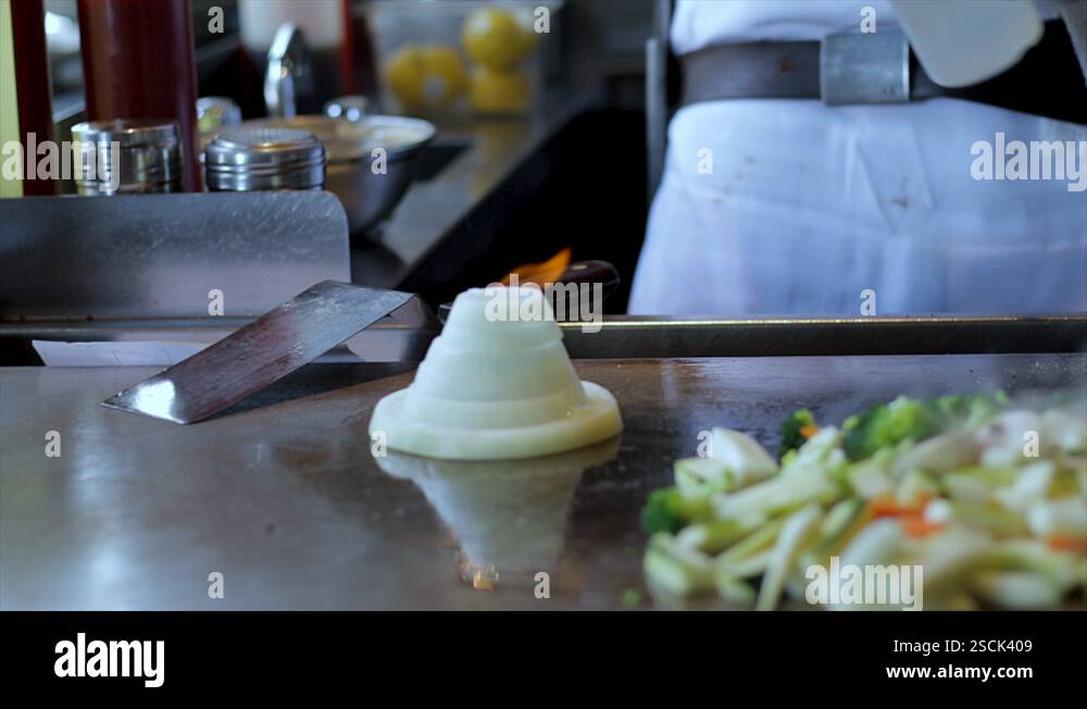 Japanese food performance. Chef lighting a fire volcano made of onions ...