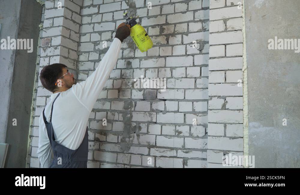 construction worker moisturing brick wall with water sprayer Stock ...