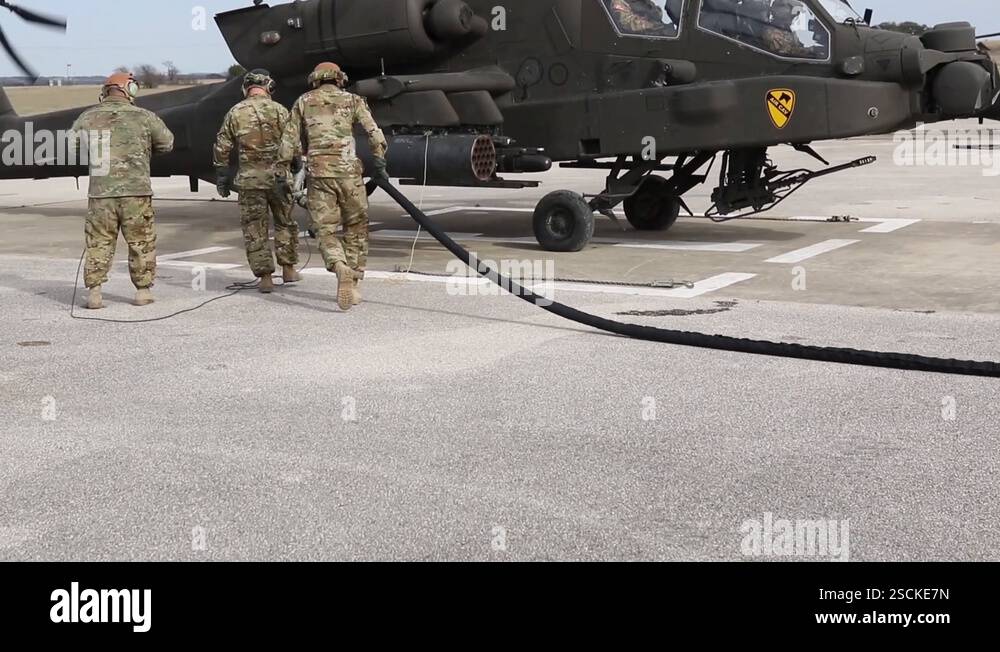 Soldier carring fuel hose to AH-64 apache during FARP Operations Stock ...