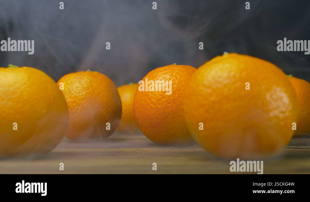 fresh Mandarin oranges are on the table in cold, steam from frost in ...