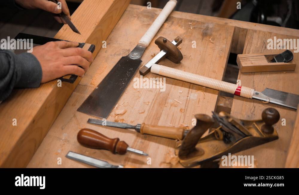 carpenter marks the workpiece with a square and marking knife Stock ...