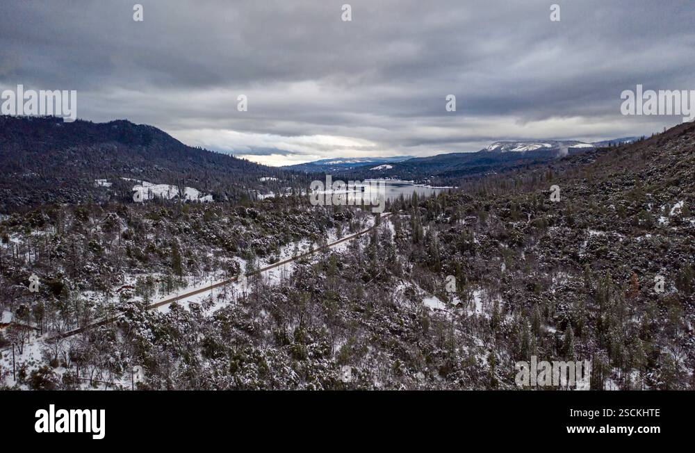 Aerial hyper lapse rising revealing a lake surrounded by winter ...