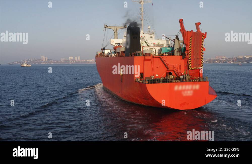 Flying next to cargo ship, aerial veiw of ship's back and port side ...