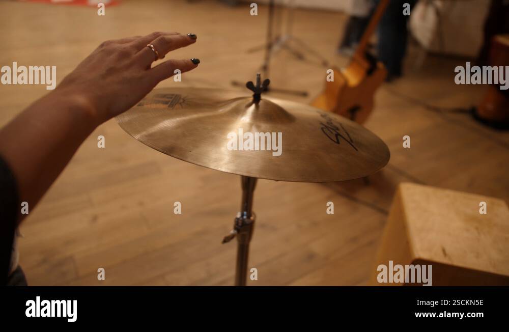 Woman shows a cymbal to her kid. Baby tries to make a sound with a ...