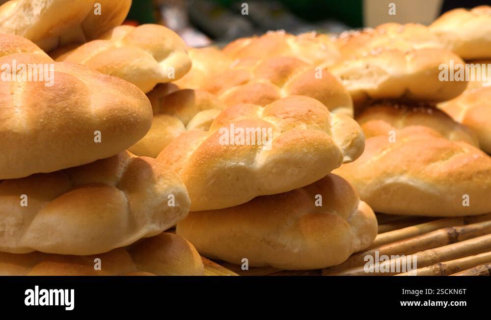 A baker takes bread rolls off a shelf in a bakery - closeup Stock Video ...