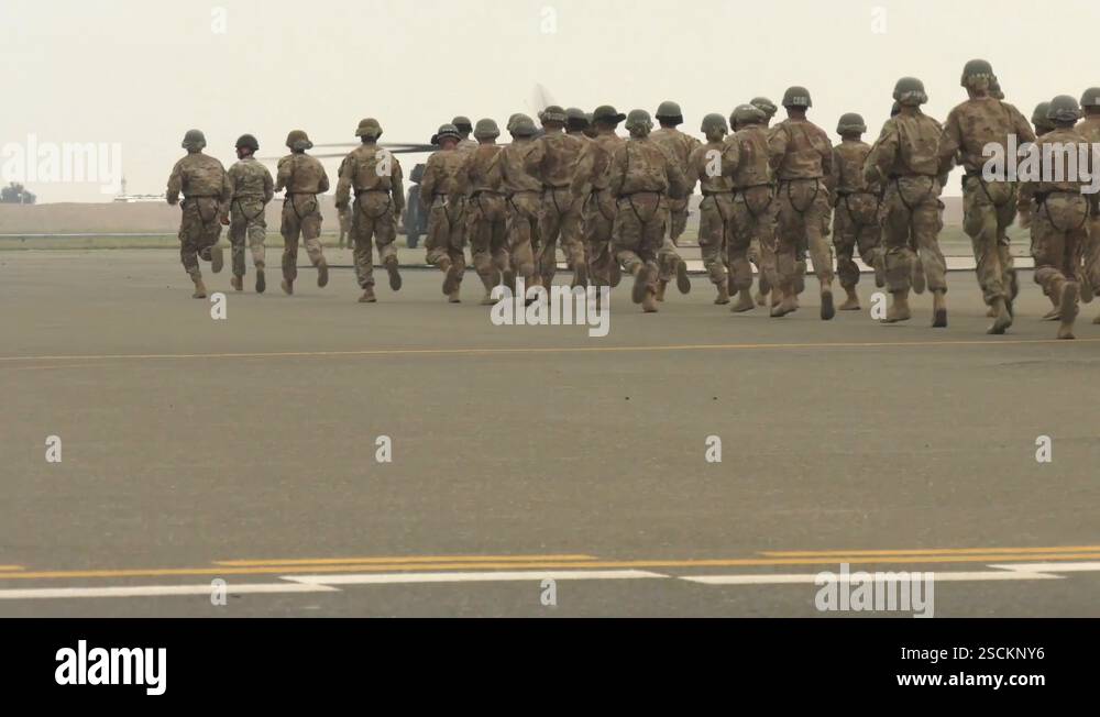 Soldiers running towards UH-60 Black Hawk for fast rope training ...