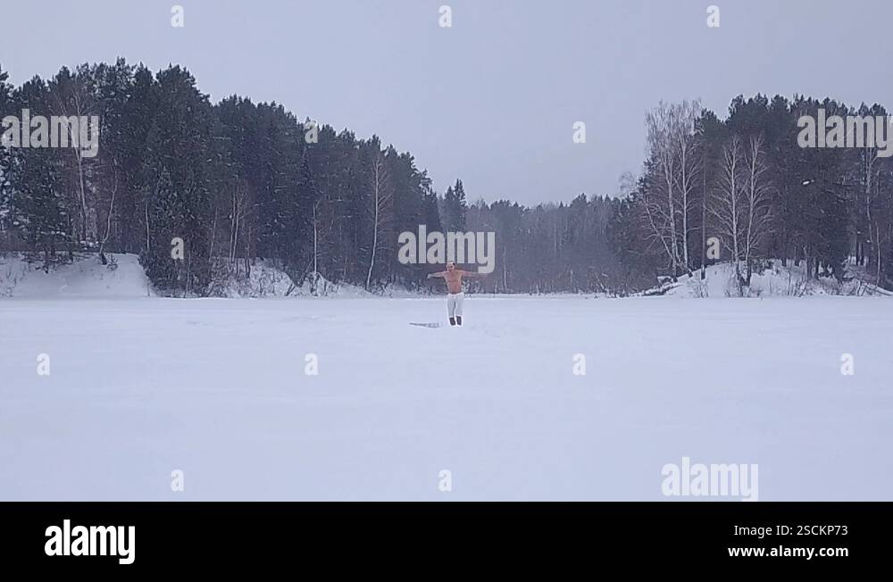 Young man jumps into the ice hole Stock Video Footage - Alamy