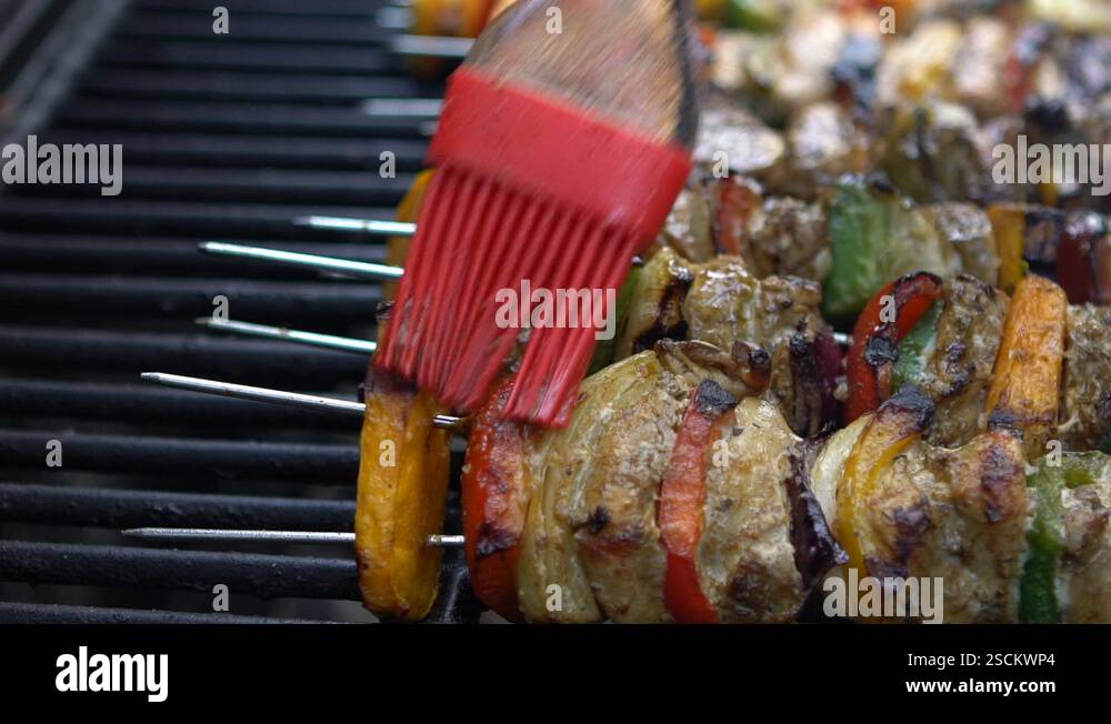 Slow Motion of chef covering with sauce the delicious skewers on BBQ ...