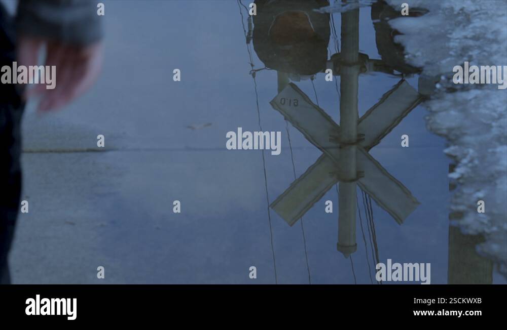 People walking through puddle with reflections. Railway sigh reflecting ...