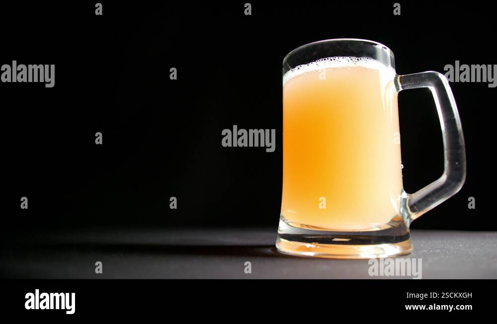 Big glass of alcohol malt beer on table during party at nightclub ...