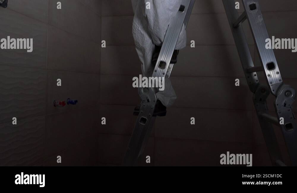 Constructor man standing on ladder and drilling holes in ceiling Stock ...