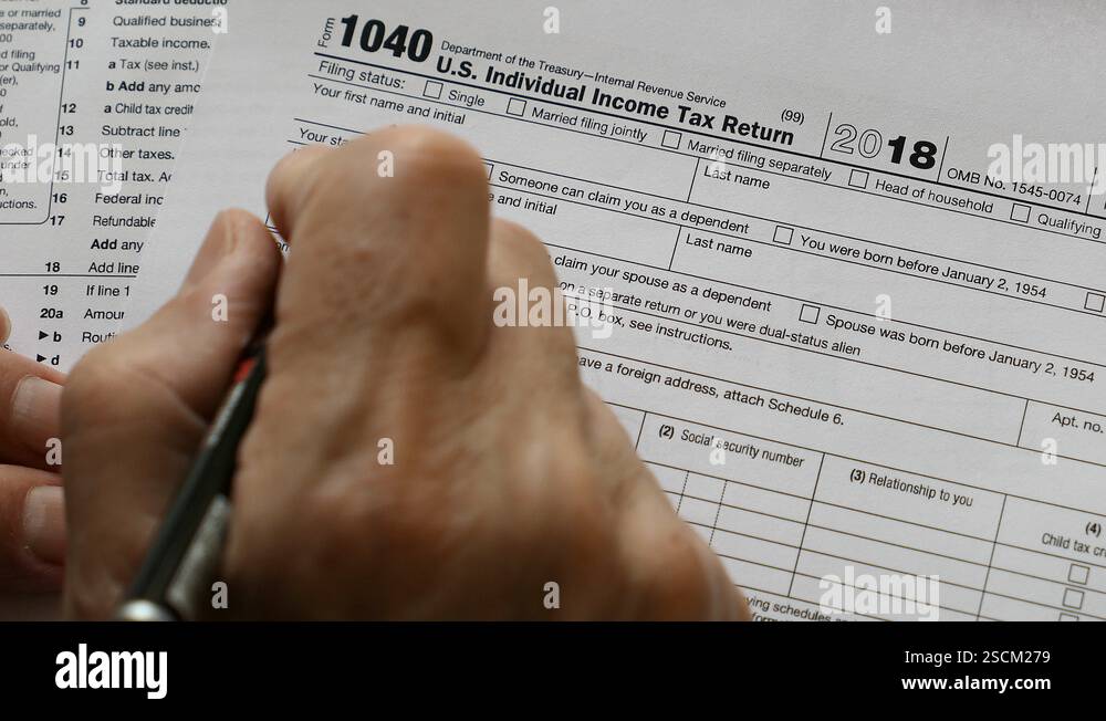 An Elderly Man Signs Irs Us Individual Income Tax Form 1040. Fake ...