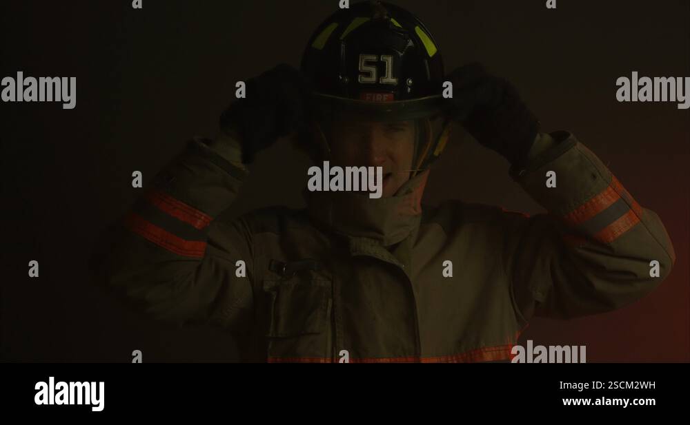 Firefighter puts arms on hips and looks directly towards camera ...