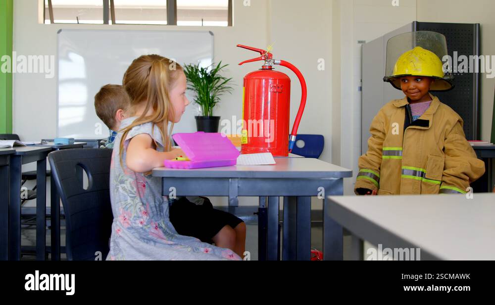 Caucasian boy and girl listening to Caucasian male firefighter and ...
