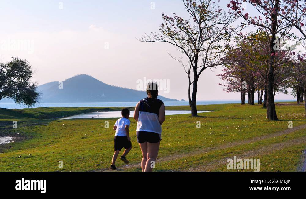 woman jogging in natural sunlight in the evening, along with his son ...