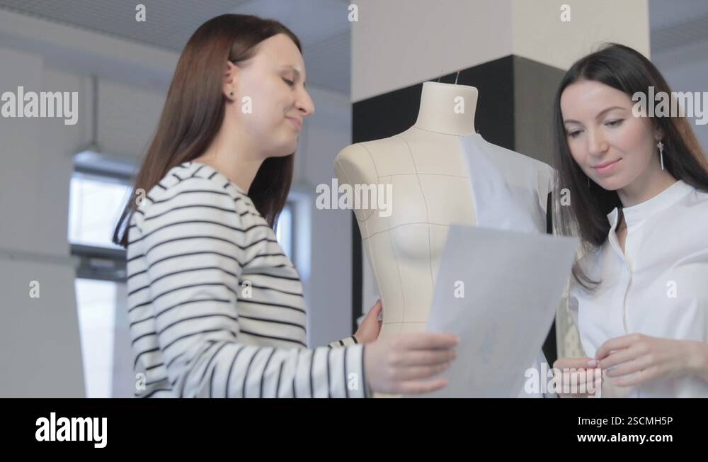 two girls of the fashion designer discuss in sewing salon Stock Video ...