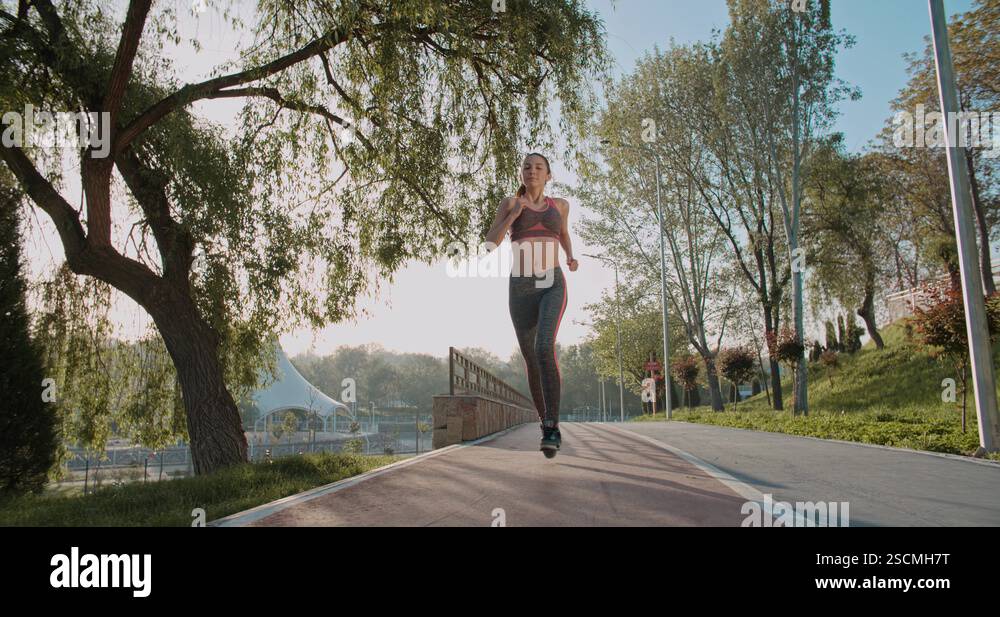 Female turkish runner running down the track in summer park during sunrise Stock Video Footage ...